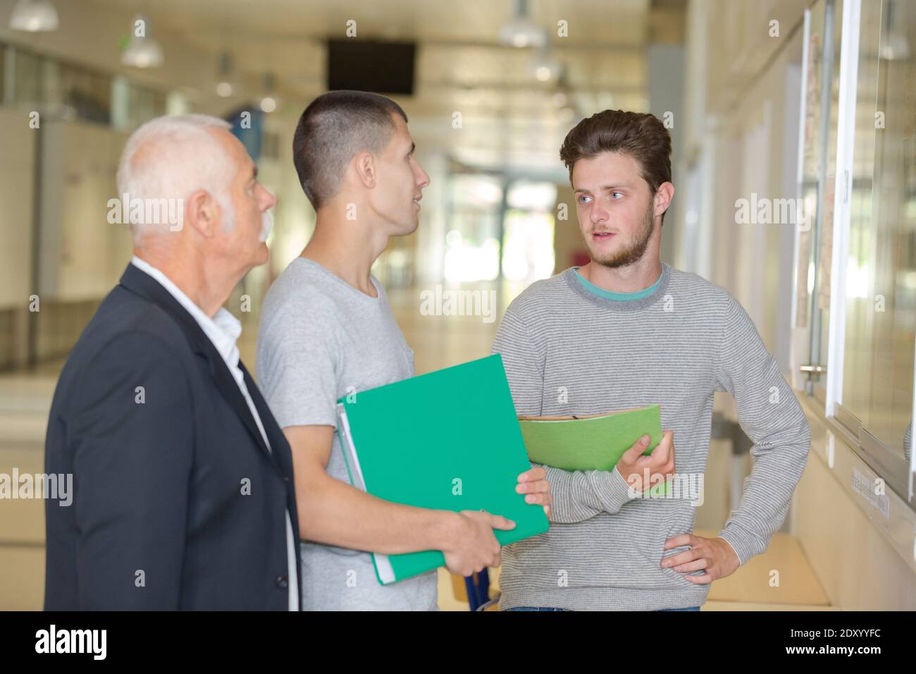 professor talking to students in corridor Stock Photo - Alamy