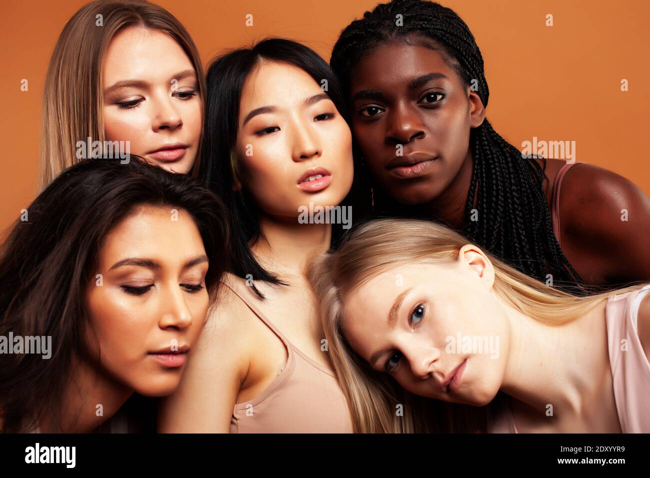 young pretty asian, caucasian, afro woman posing cheerful together on brown background ...