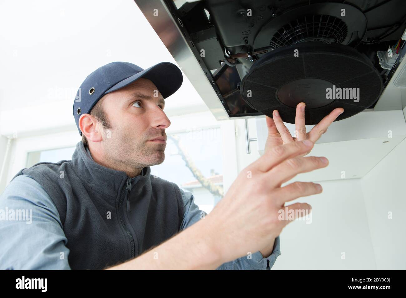 fixing a kitchen extraction unit Stock Photo - Alamy