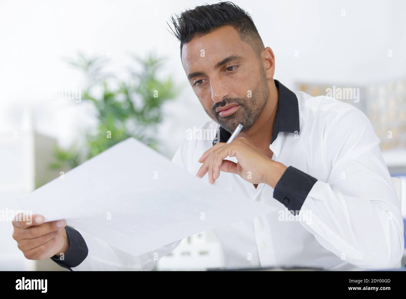 male architect verifying data information from map on blueprint Stock ...