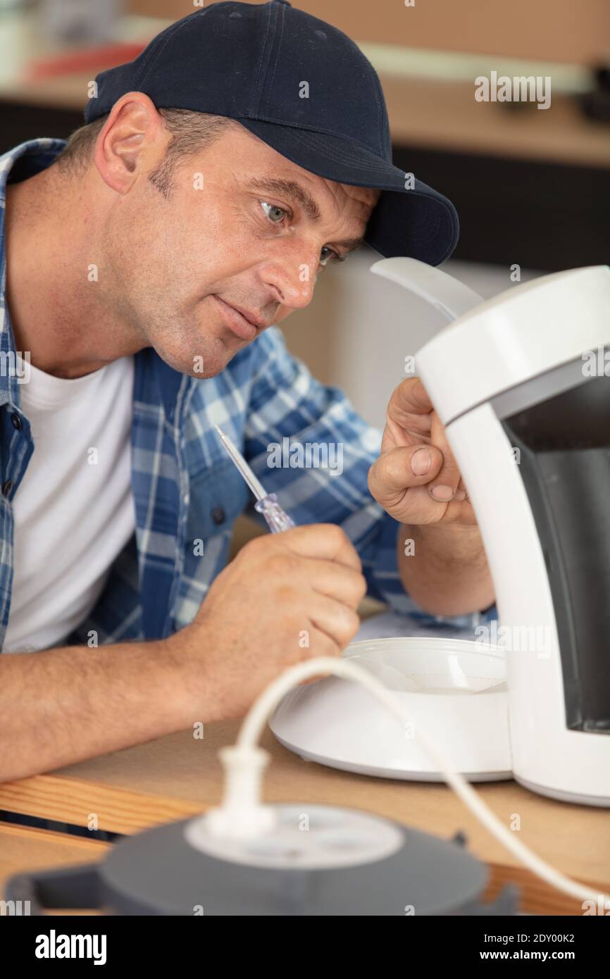 mature man repairing broken coffee machine Stock Photo - Alamy
