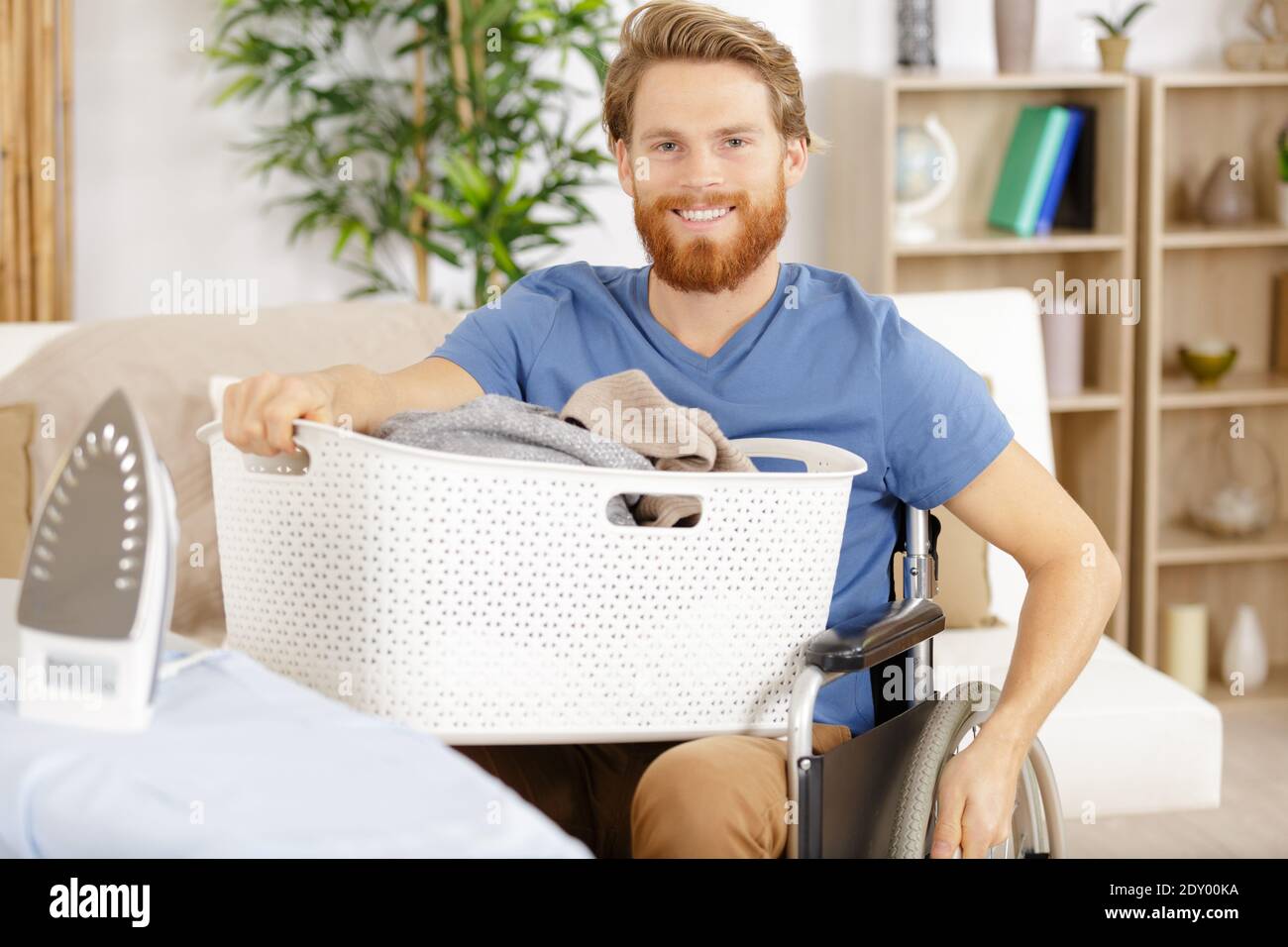 happy disabled man on wheelchair doing laundry Stock Photo - Alamy