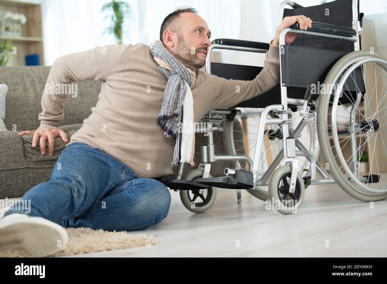 man fell off wheelchair sitting on the floor Stock Photo - Alamy