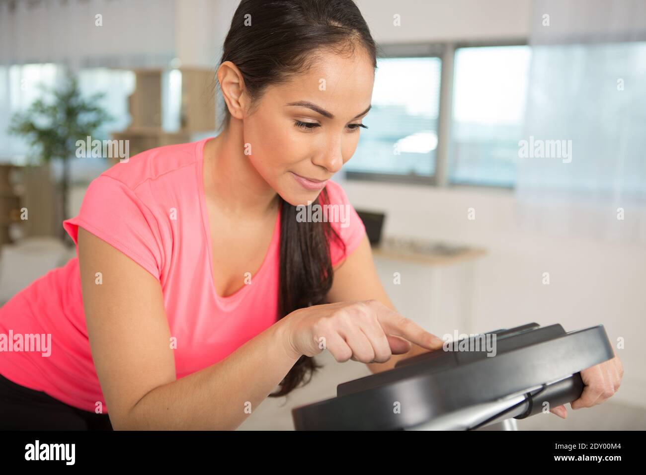 woman checking settings of a step machine Stock Photo - Alamy