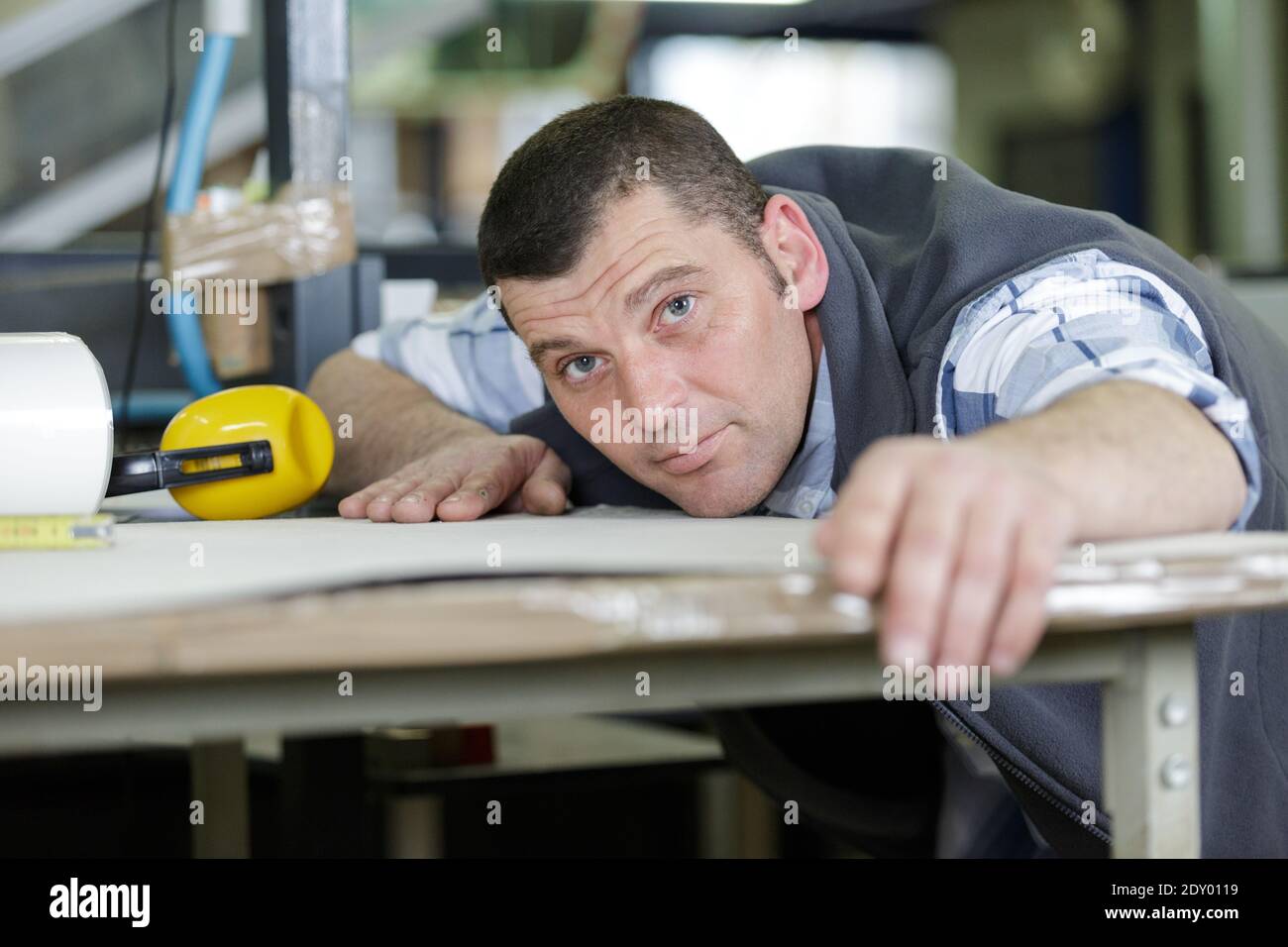positive smiling diligent man checking a piece of wood Stock Photo - Alamy