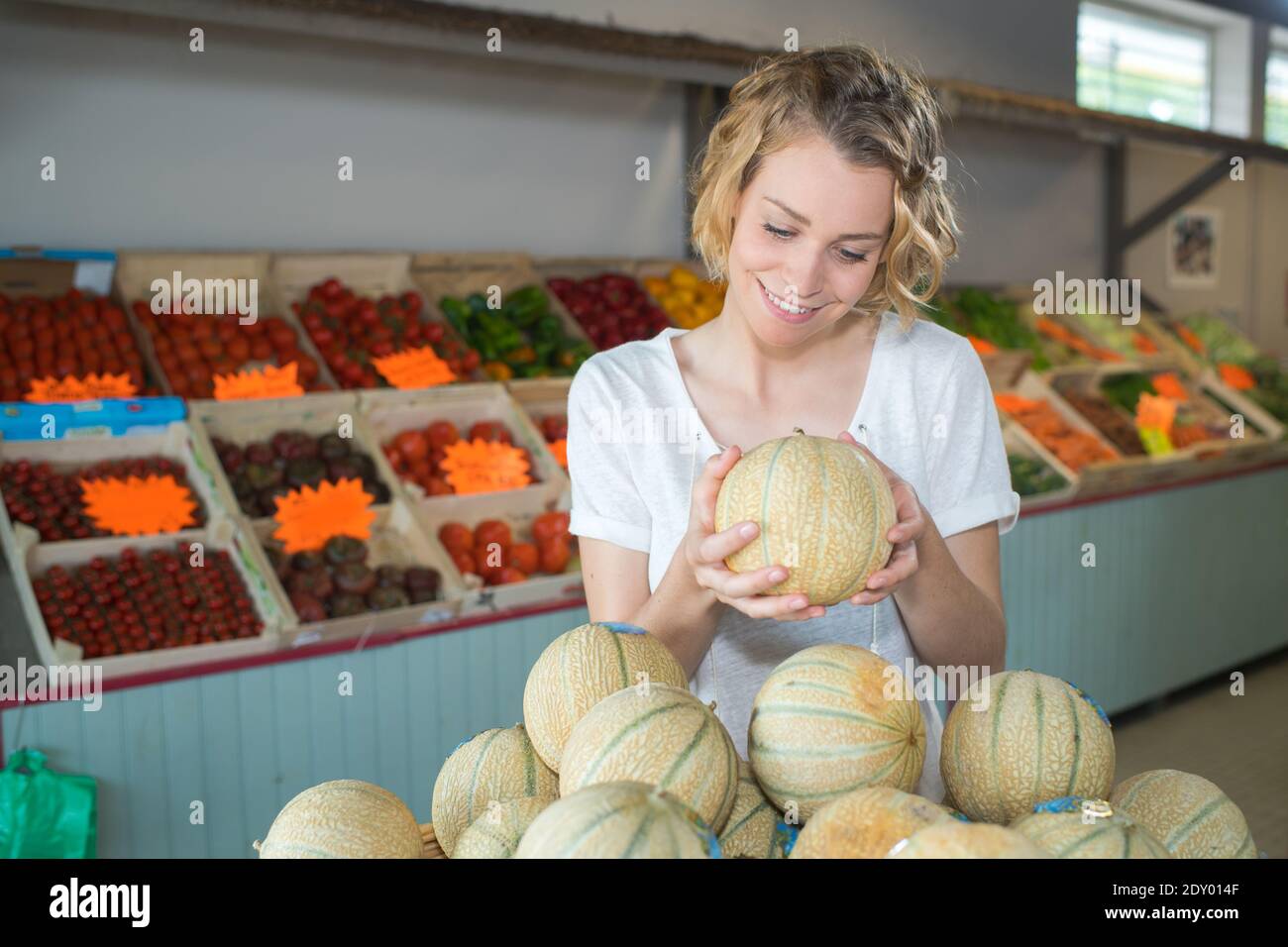 female customer checking a melon in market Stock Photo - Alamy