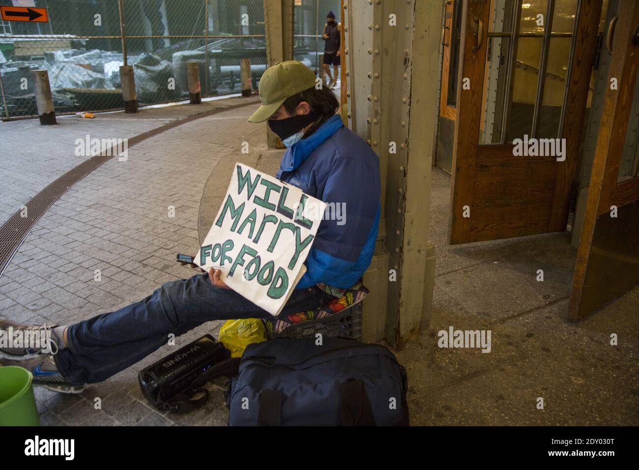 Homeless man with a sense of humor sits outside an entrance to Grand ...