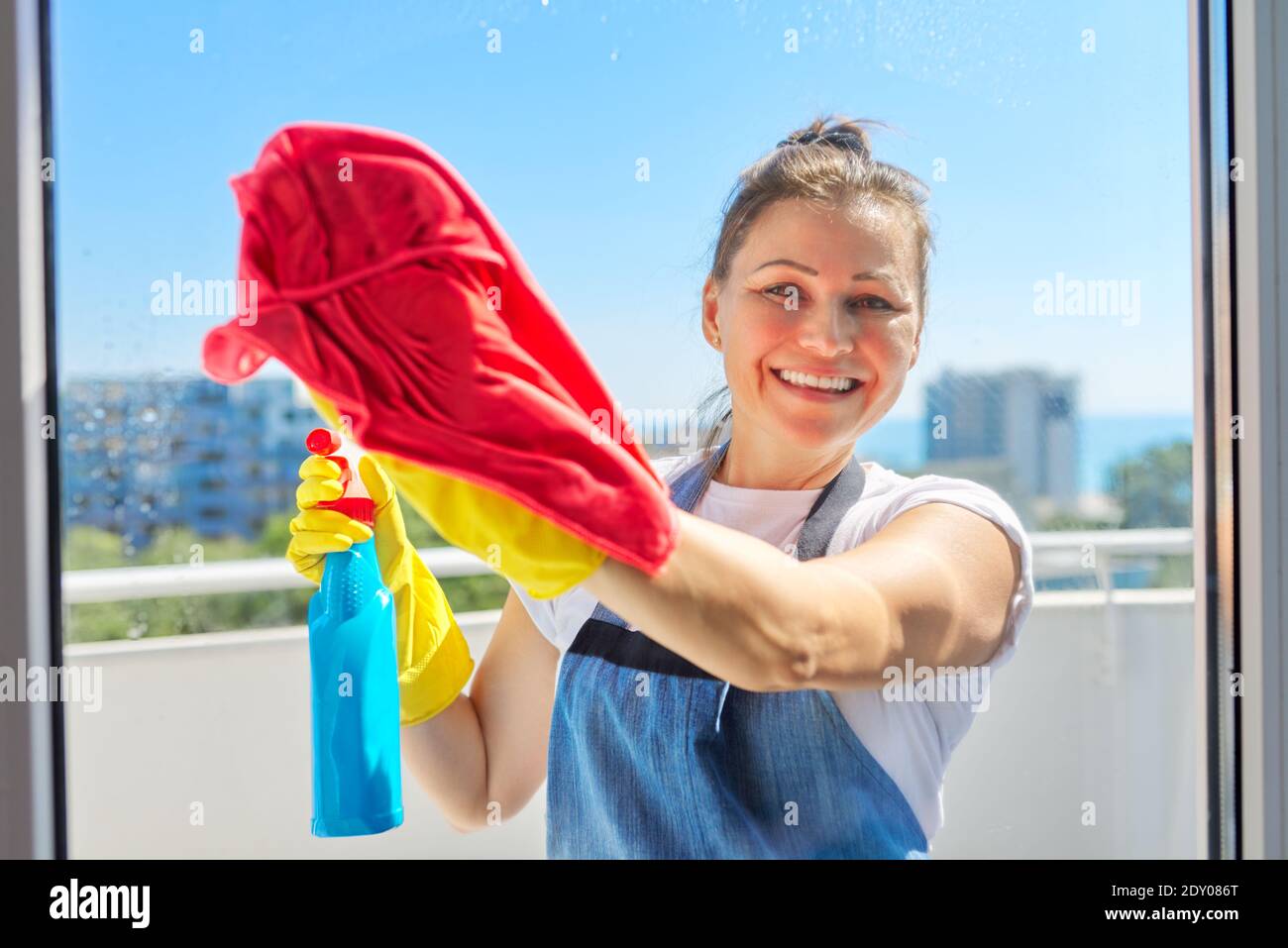 Portrait of mature positive woman washing window Stock Photo - Alamy
