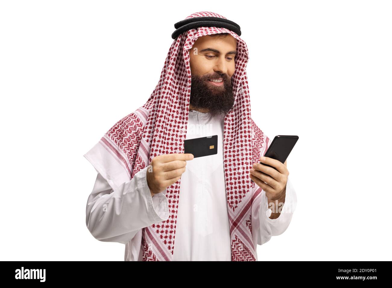 Saudi arab man using a credit card with a mobile phone isolated on ...
