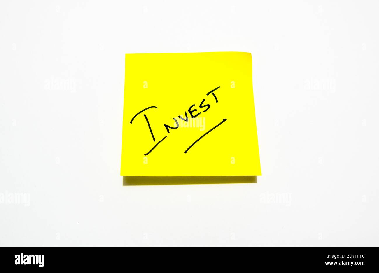 Invest sticky note on white background Stock Photo - Alamy