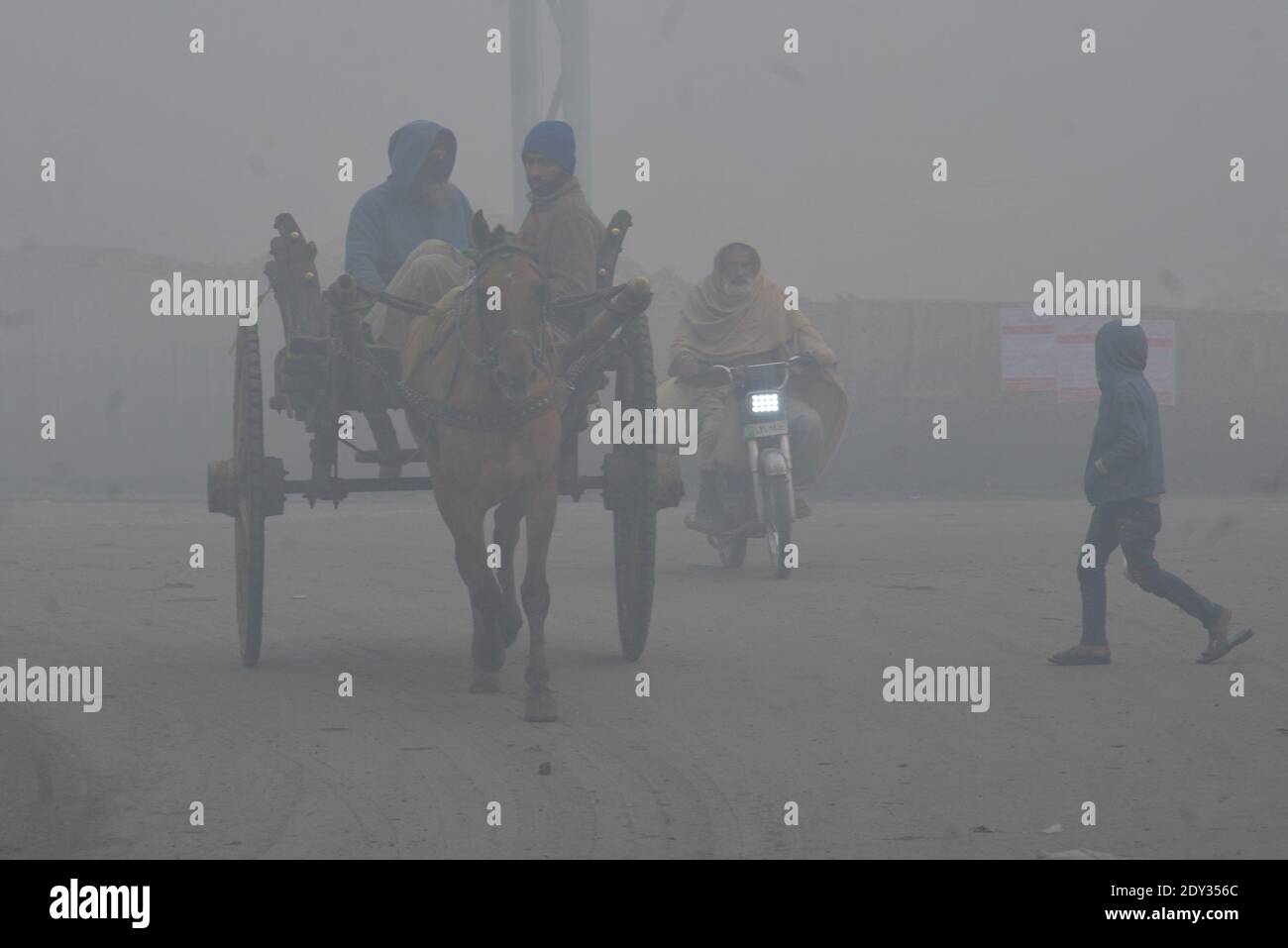Pakistani Commuters make their way amid dense fog on a cold winter ...