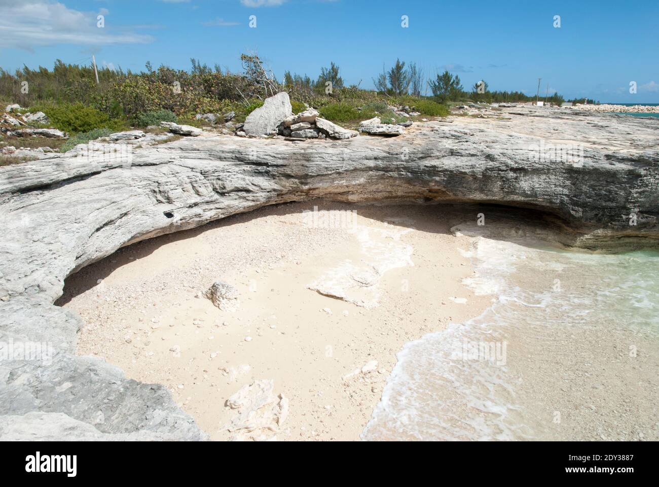 The tiny beach surrounded by eroded rock on a shore of Grand Bahama ...