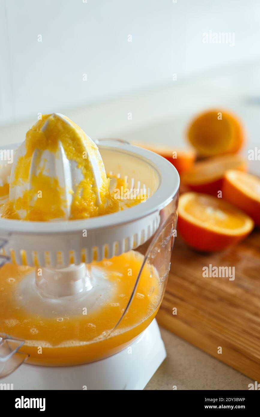 A vertical shot of squeezing orange juice Stock Photo - Alamy
