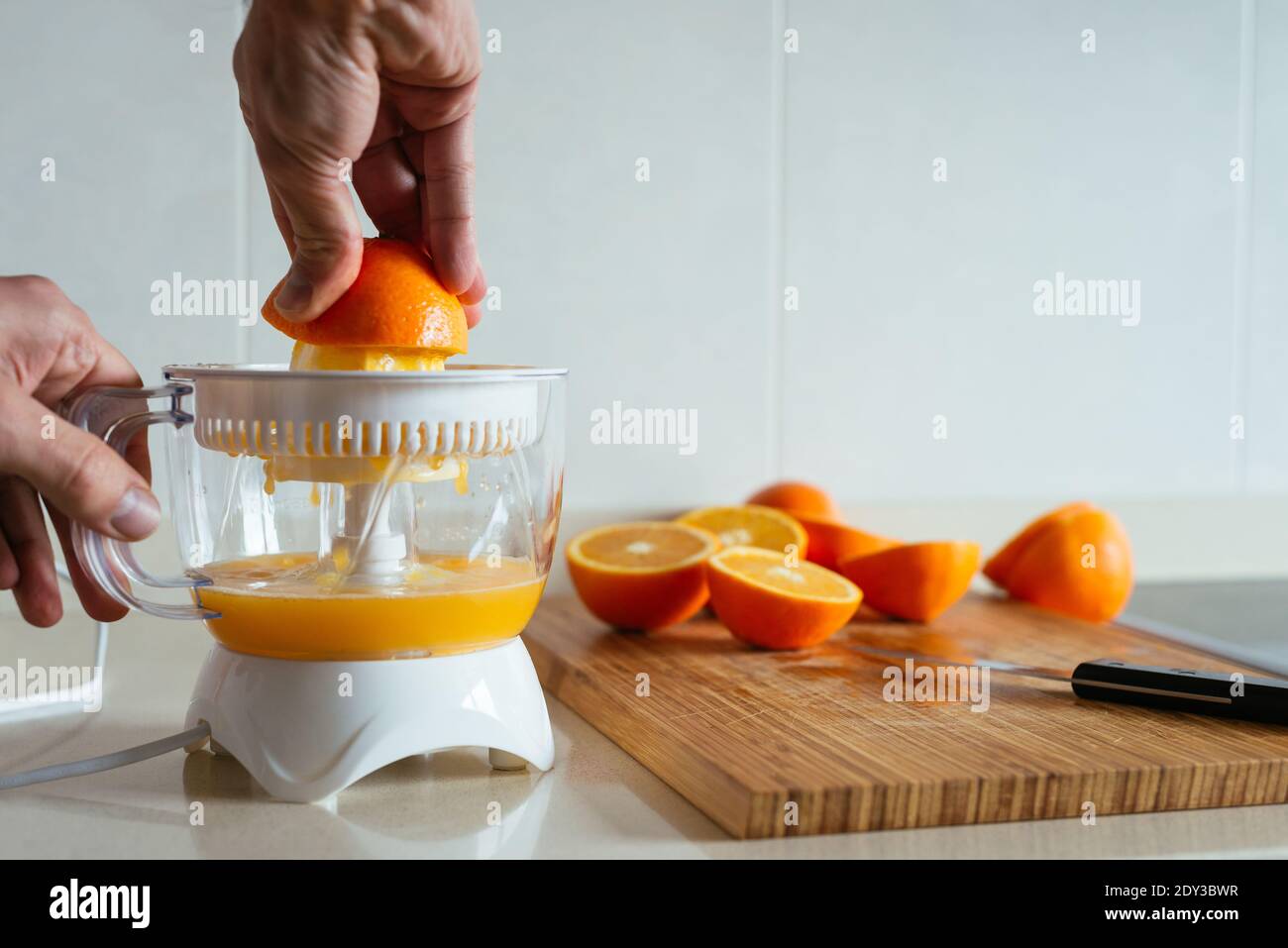 A closeup shot of squeezing orange juice Stock Photo - Alamy