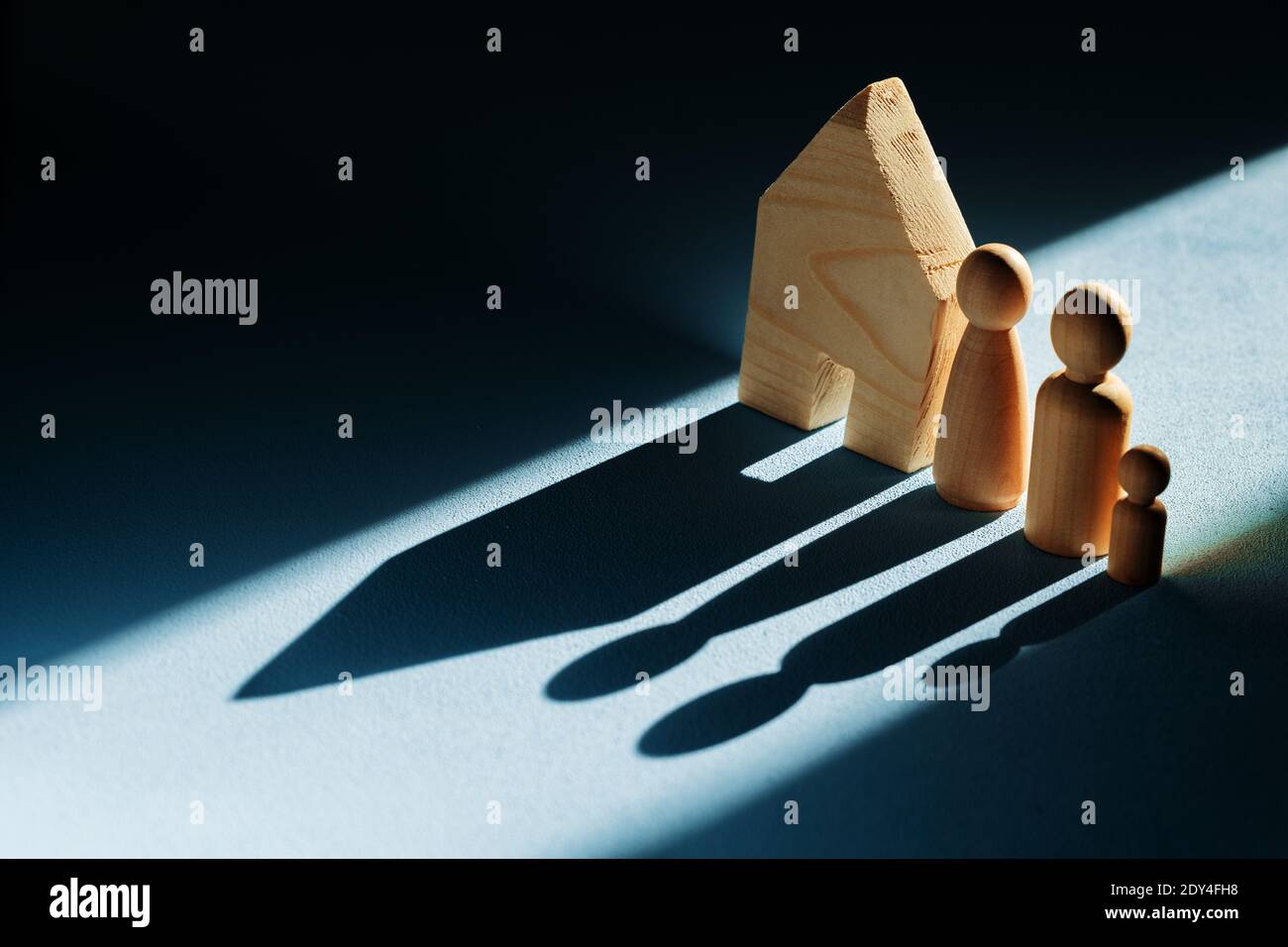 Miniature wooden house with shadows on blue background Stock Photo - Alamy