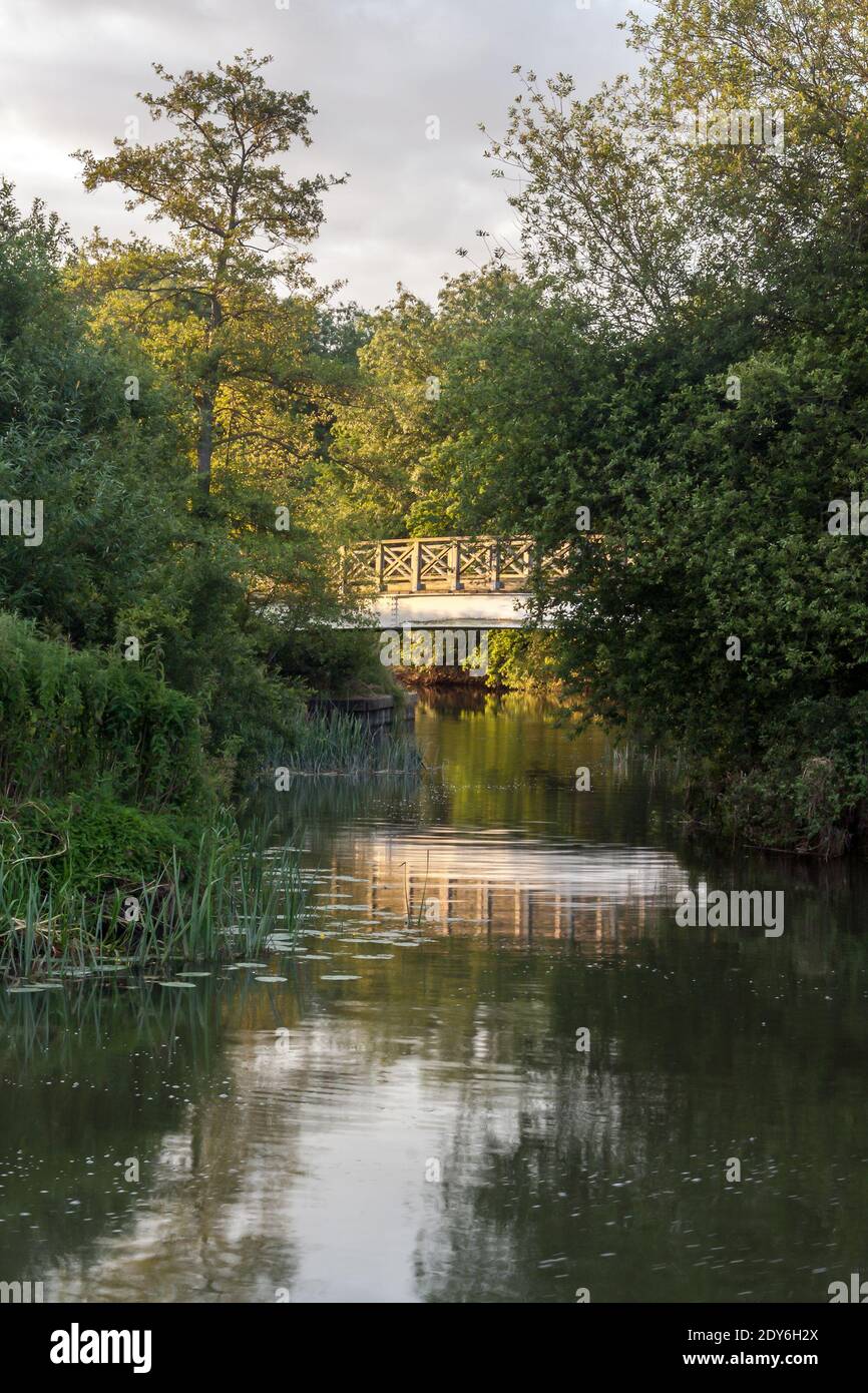Pretty wooden footbridge over small river with reflection Stock Photo ...