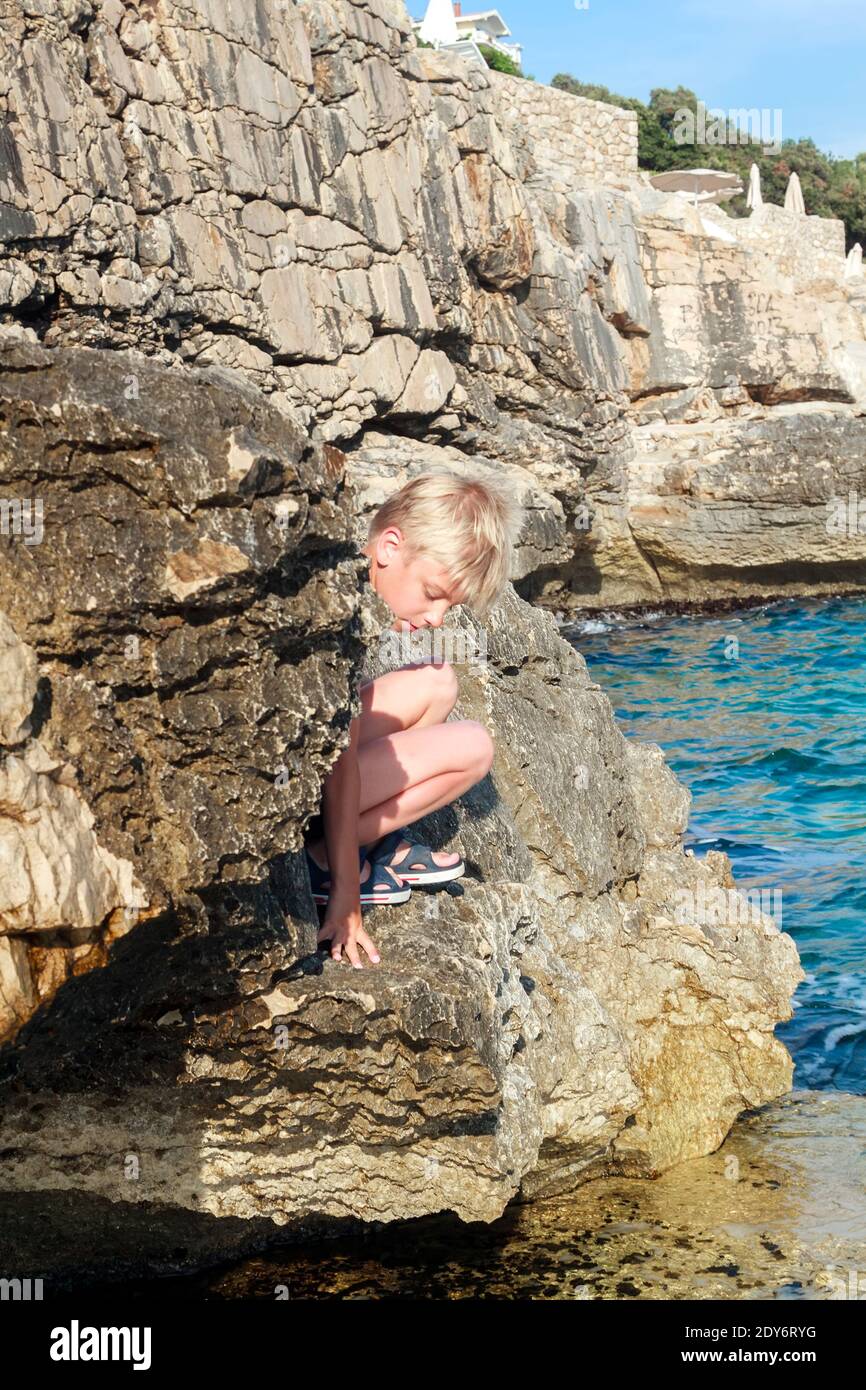 Full Length Of Cute Boy Looking At Rock Stock Photo - Alamy