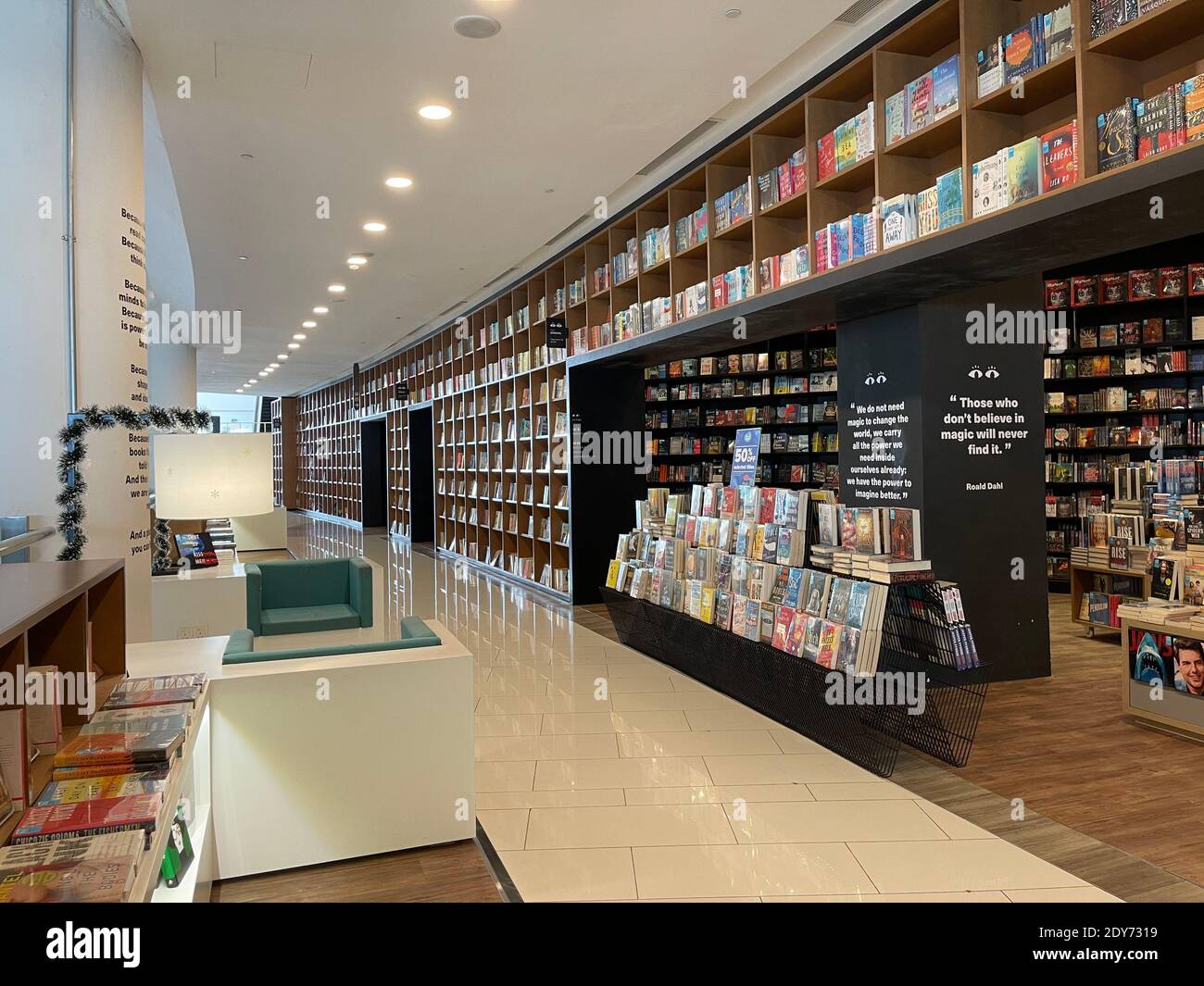 Rows of different colorful books lying on the shelves in the modern ...