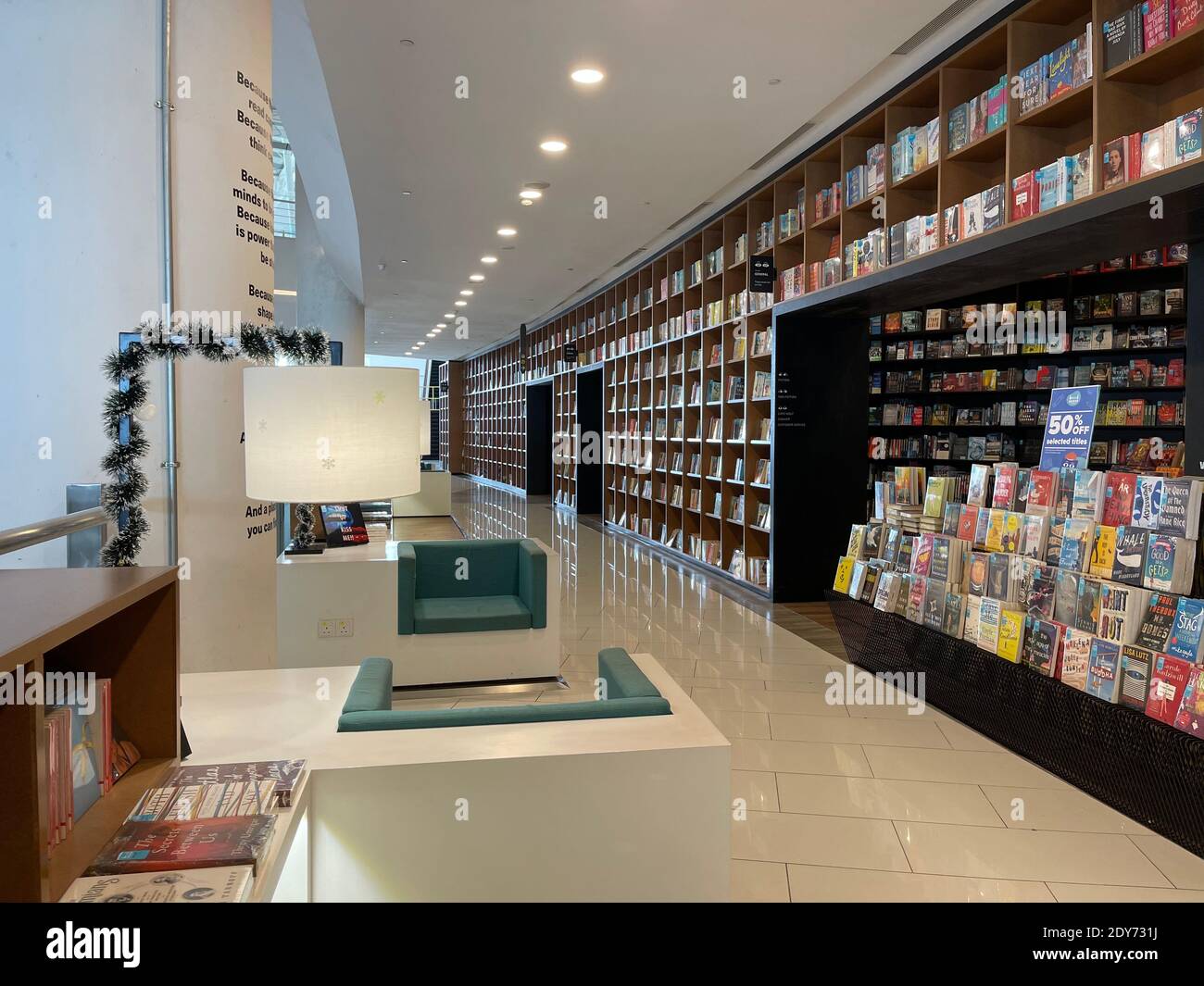 Rows of different colorful books lying on the shelves in the modern ...