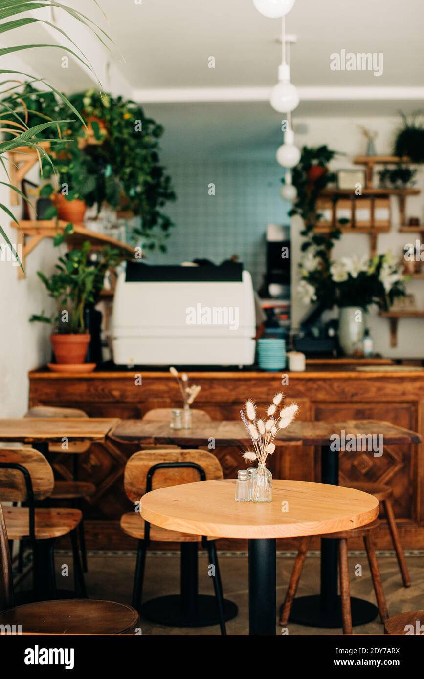 Empty cafe with wooden tables and green plants in Lisbon Stock Photo ...