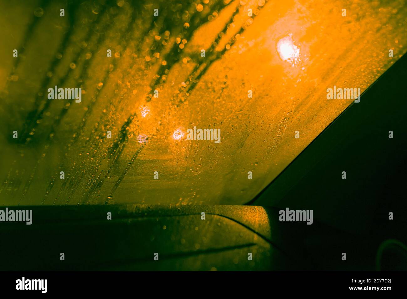 Rain drops in a raining day on window car with lamp street. Dewdrops ...