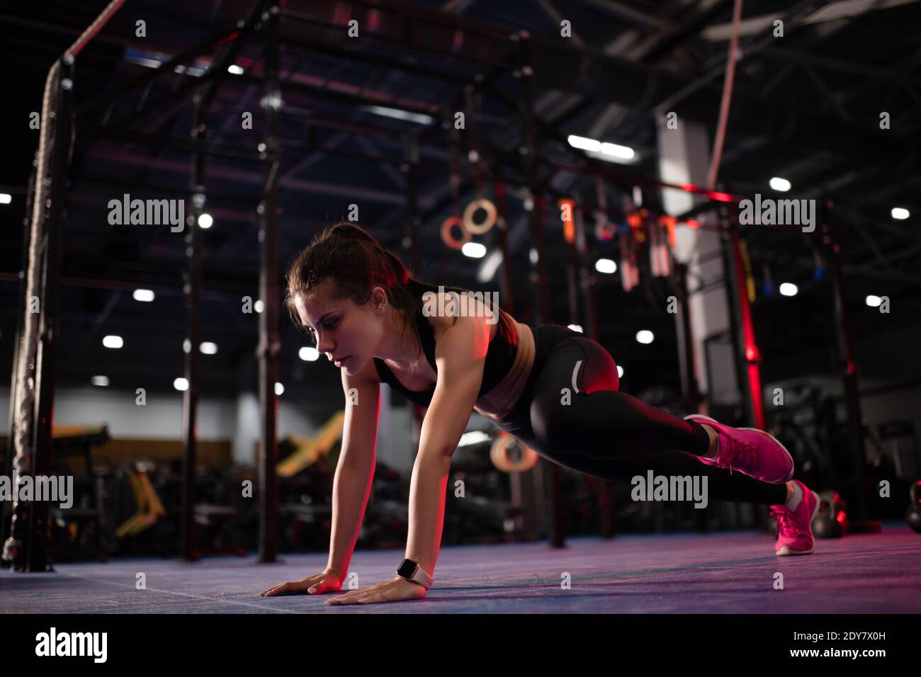 Powerful female athlete doing exercise for abs during intense workout ...