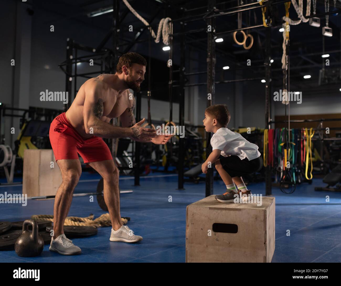 Full body little boy jumping from box to happy sportsman during fitness ...