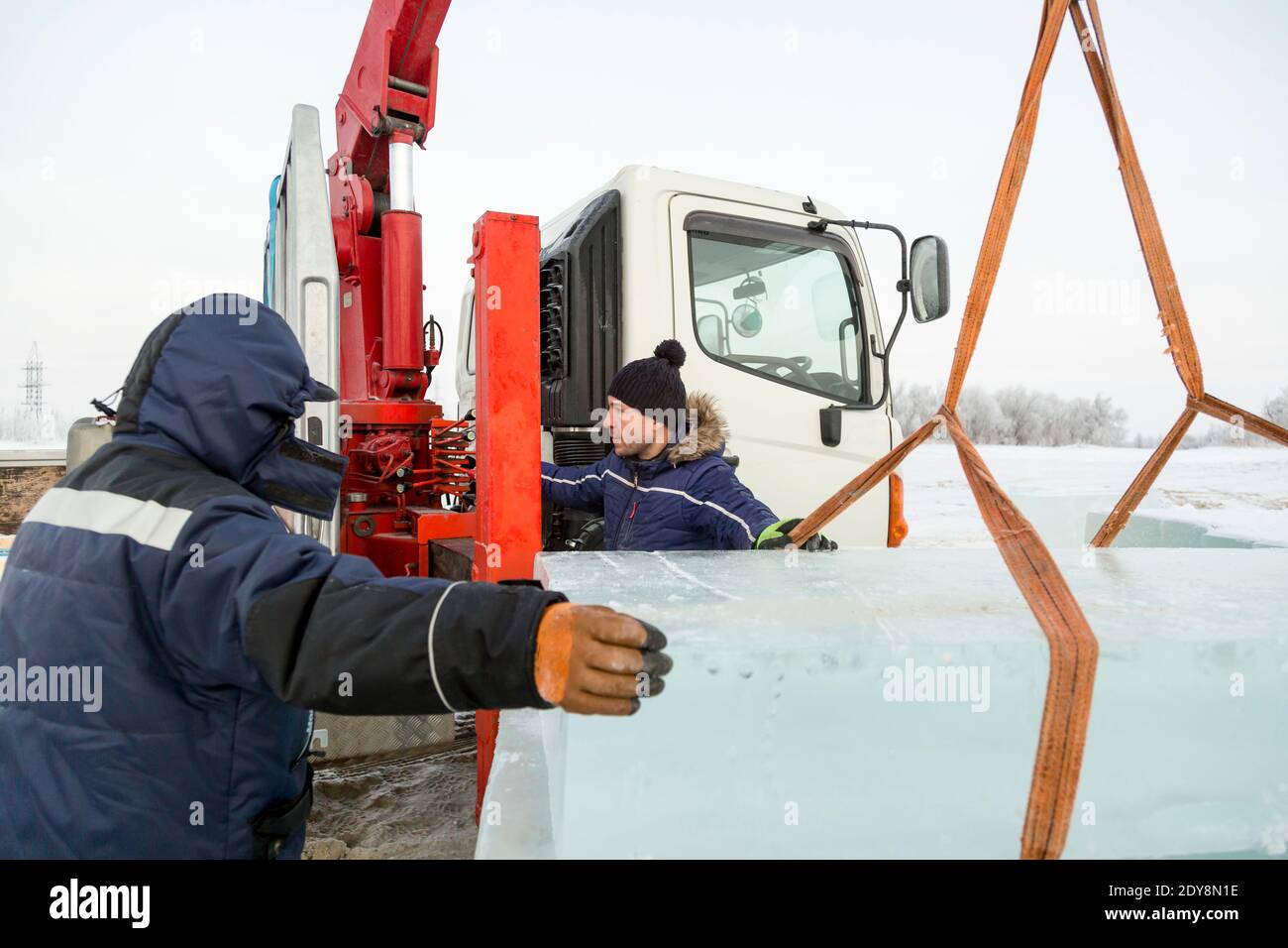 Assemblers unload ice panels from a car using a crane Stock Photo - Alamy