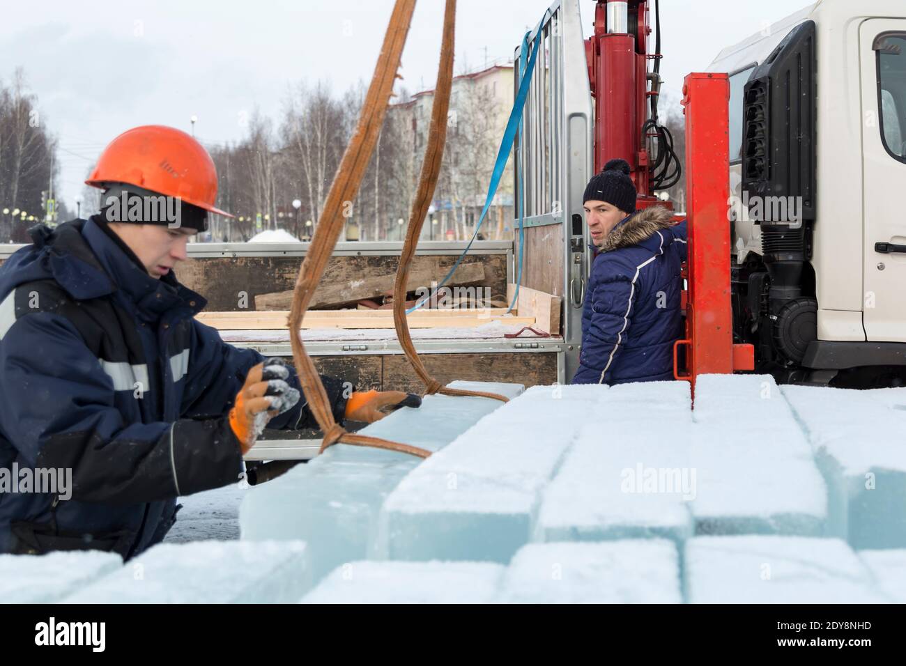 Assemblers unload ice panels from a car using a crane Stock Photo - Alamy