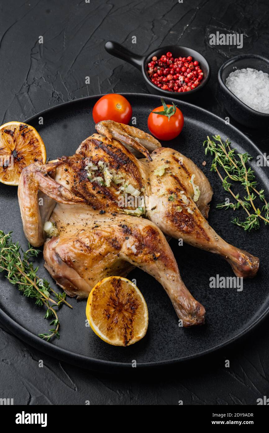 Roasted spatchcock poussin meal, on black background Stock Photo - Alamy