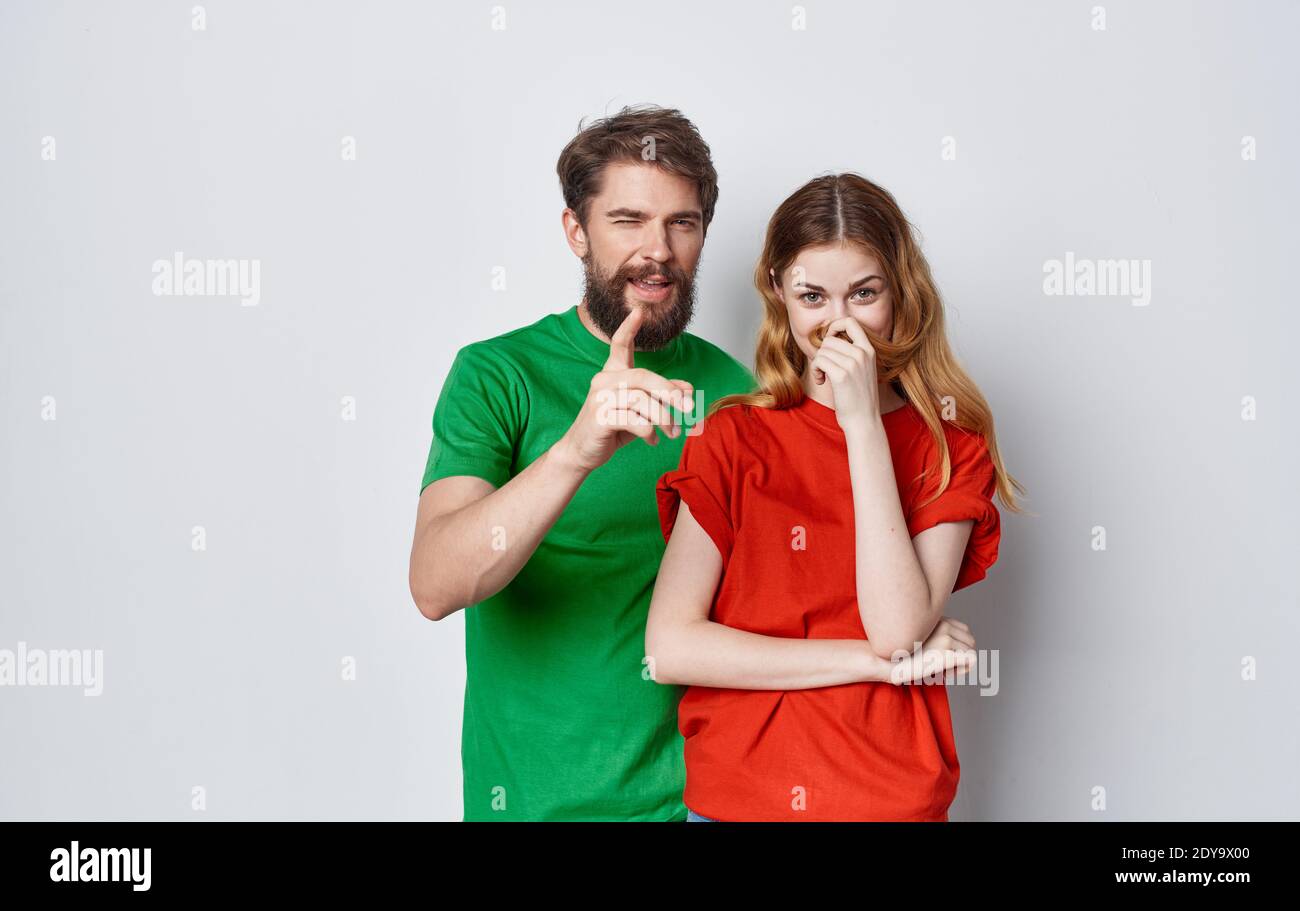 funny man and woman in multicolored t-shirts emotions hand gestures ...