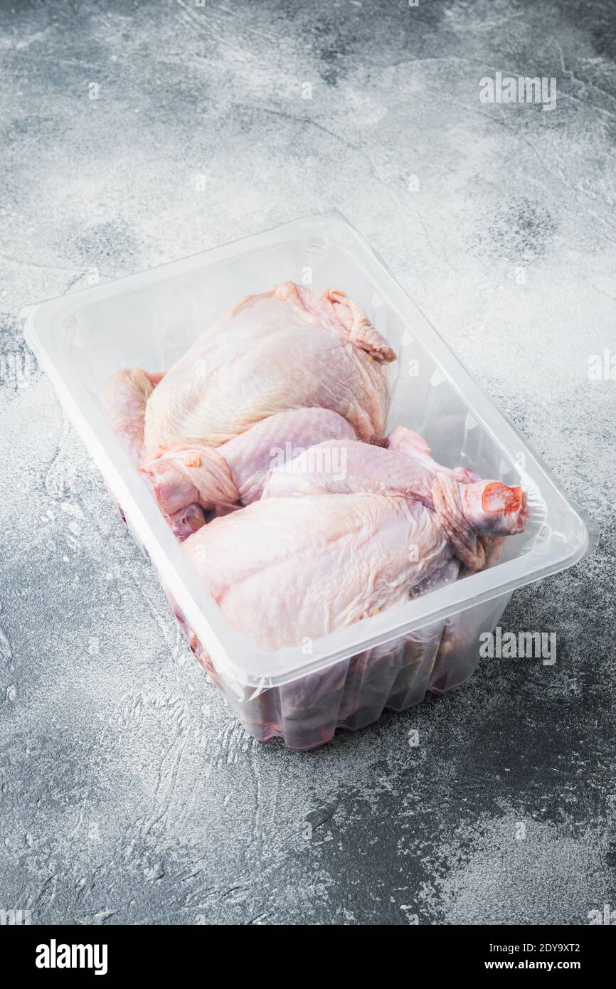 Raw chicken in plastic sealed plastic box, on gray background with copy ...