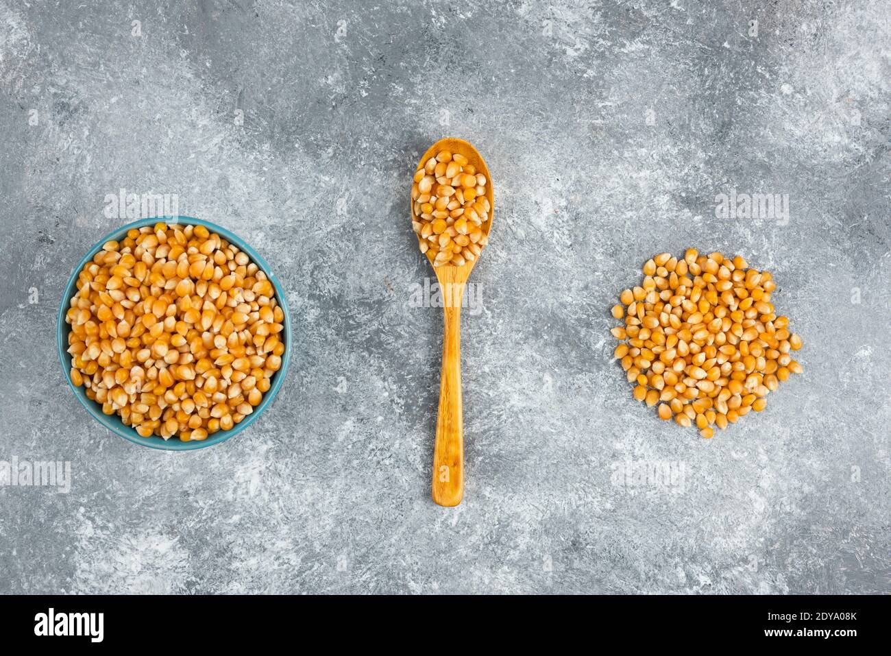 Uncooked corn kernels in blue bowl on marble surface Stock Photo - Alamy