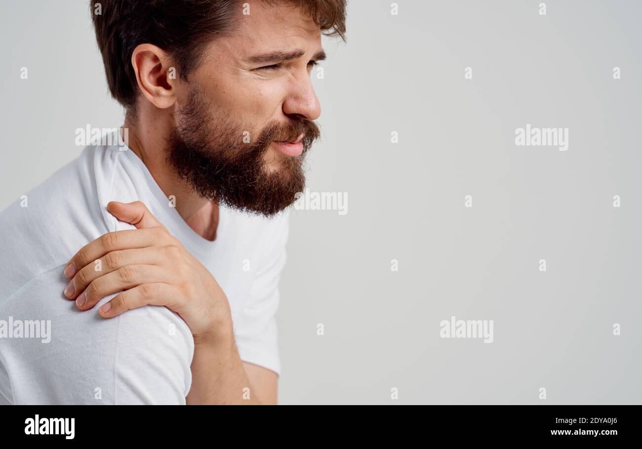 bearded man touching shoulder with hand pain dislocation medical ...