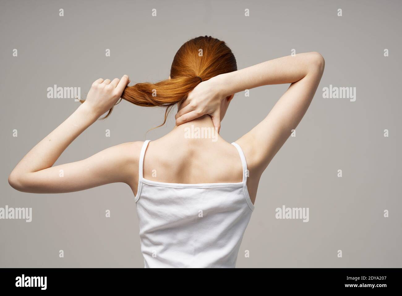 woman t-shirt touches her back with hands back view Stock Photo - Alamy