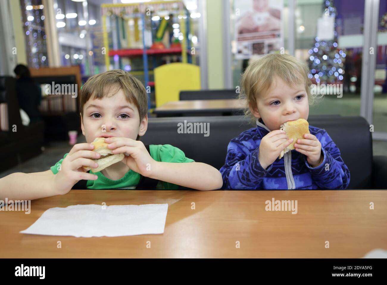 Two children have sandwiches at table in cafe Stock Photo - Alamy