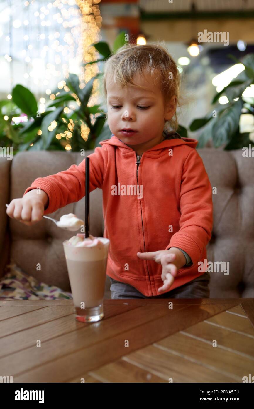 Child eating foam of cocoa in cafe Stock Photo - Alamy