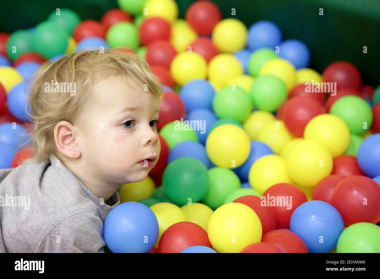 Child playing in box of balls at playground Stock Photo - Alamy