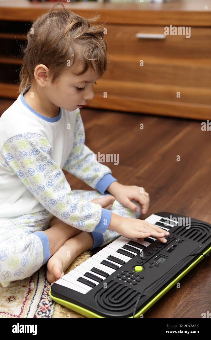 Boy playing on a synthesizer at home Stock Photo - Alamy