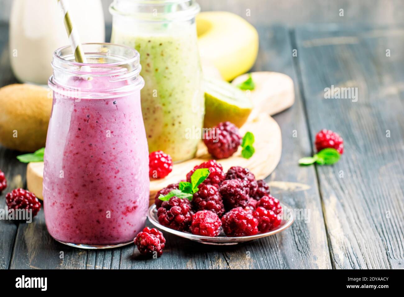 Multicolored berry and fruit smoothies, assorted in glass bottles ...