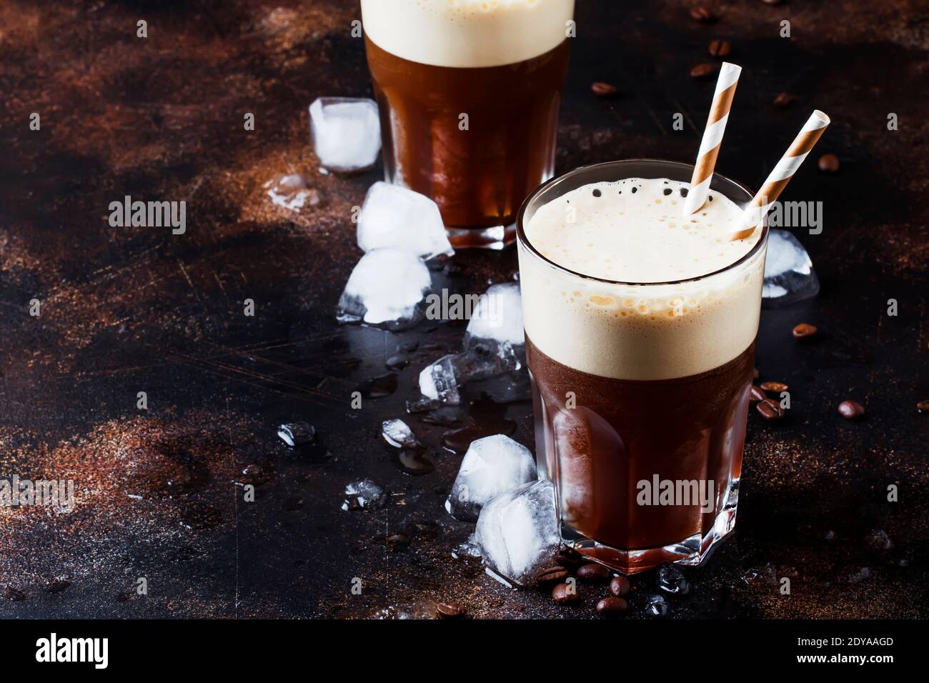 Cold frappe coffee with ice and foam in large glasses on brown ...