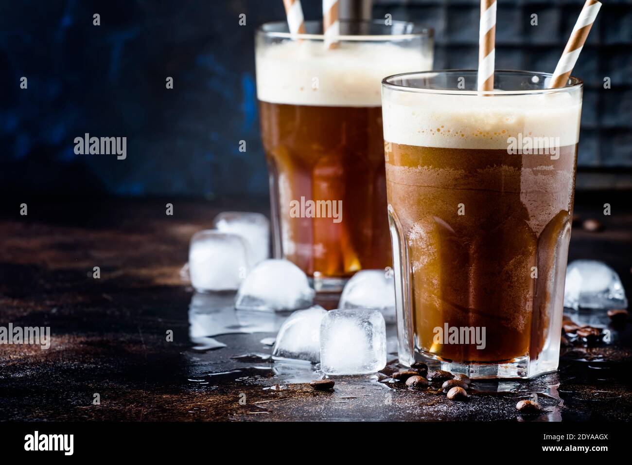 Cold frappe coffee with ice and foam in large glasses on brown ...