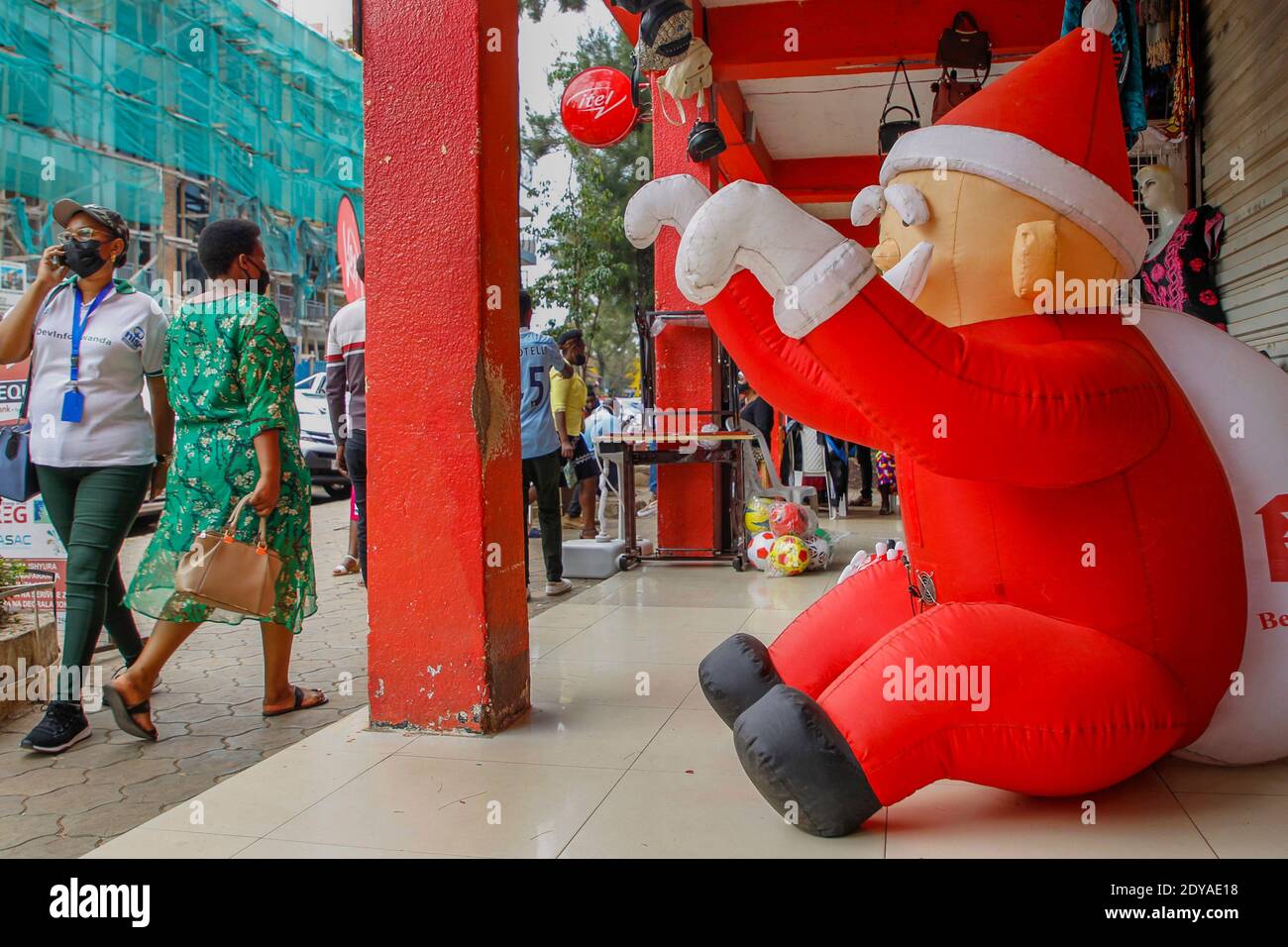 Kigali, Rwanda. 24th Dec, 2020. People wearing face masks walk past a ...