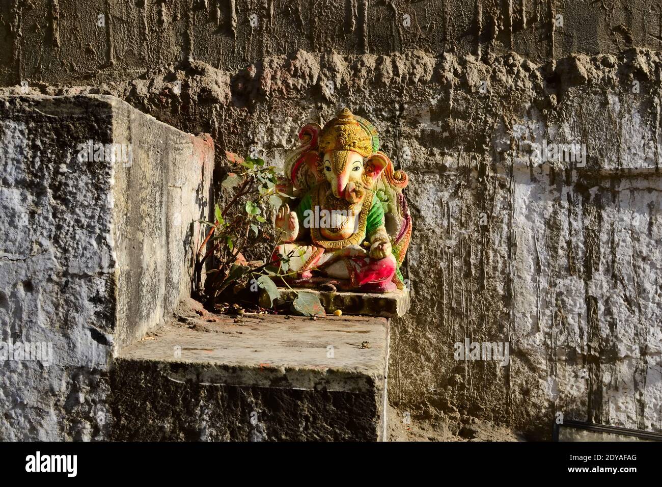 Small statue of Lord Ganesha on stairs. Colorful painted hindusim ...
