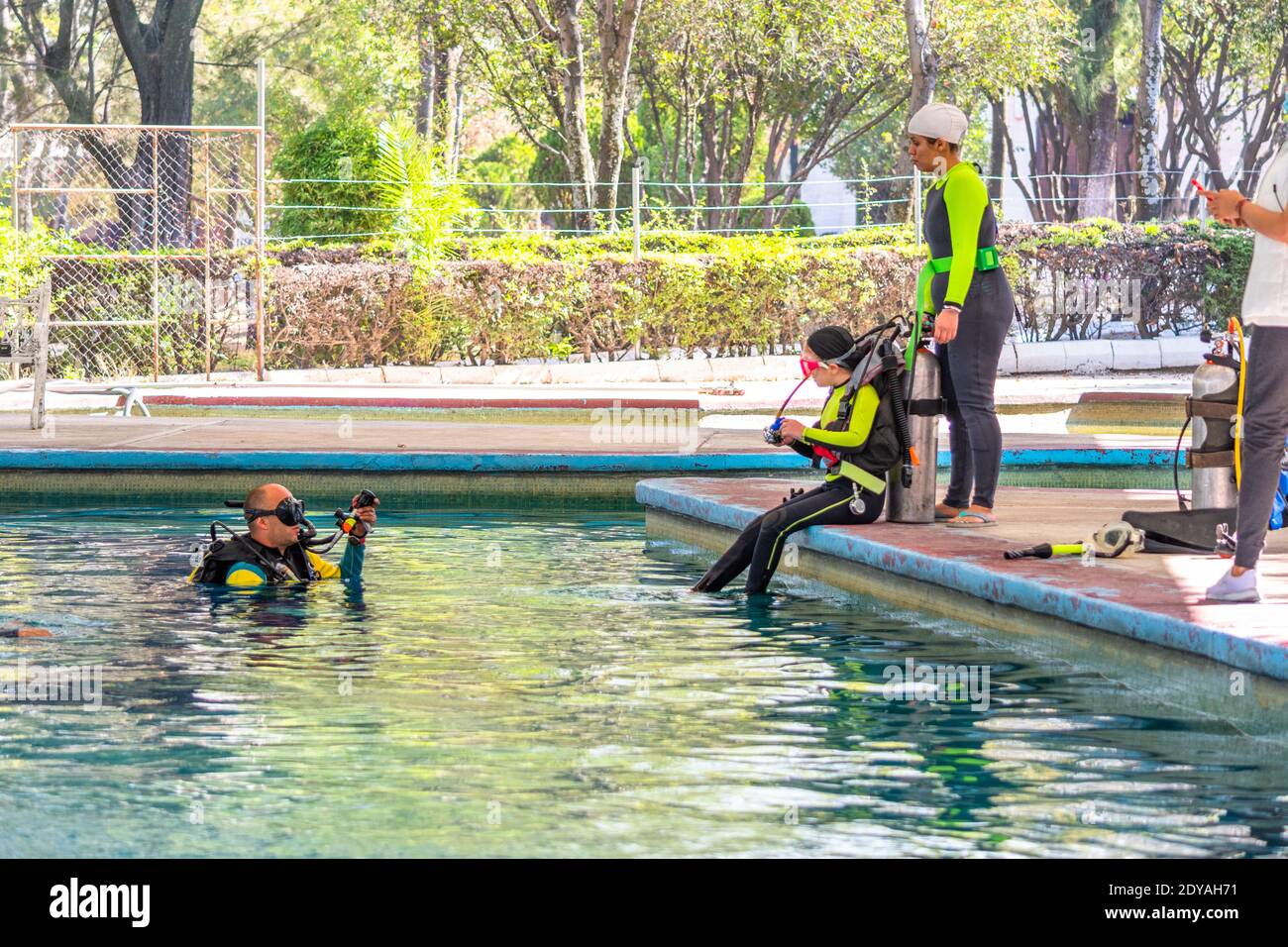 Diving class teacher correctly putting the equipment on her young ...