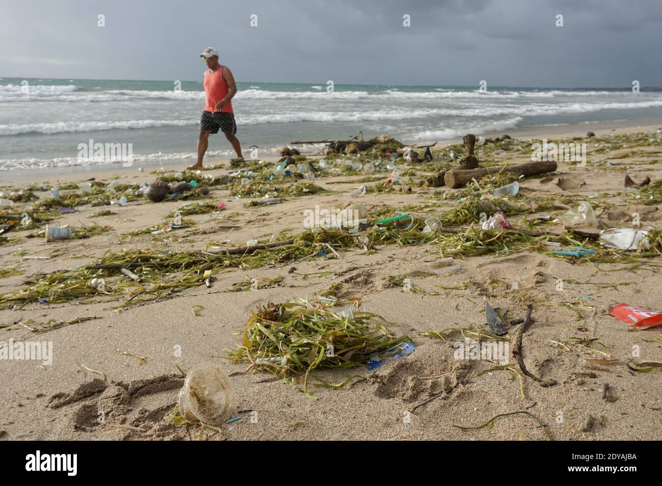 A man walks along the beach among the trashes.Tons of Trash reportedly ...