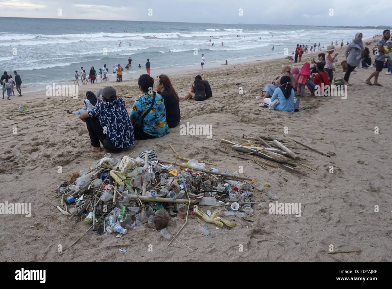 Tourists sit near trashes along the Bali Kuta Beach.Tons of Trash ...