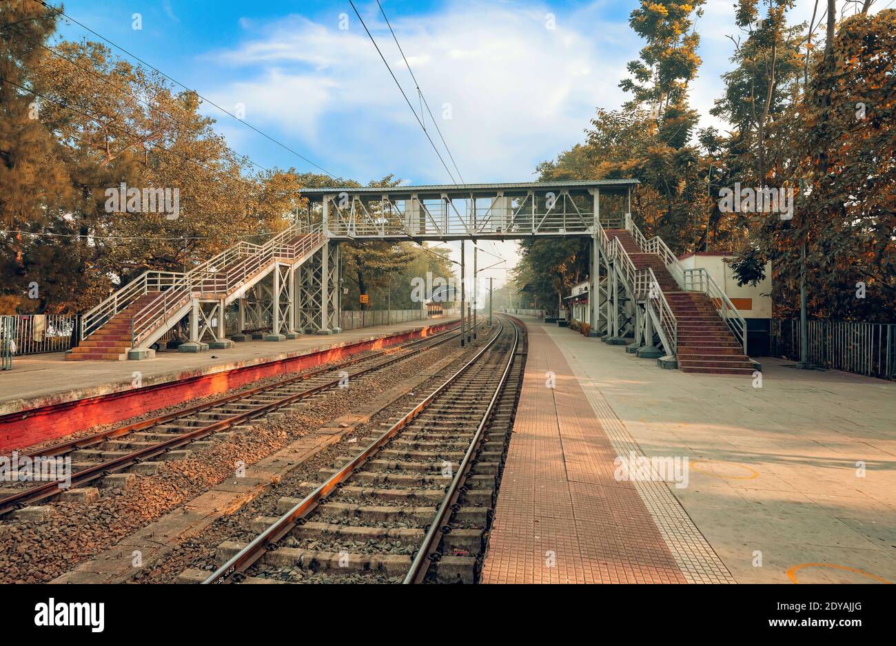 Empty train station platform with railway tracks at sunrise at Kolkata ...