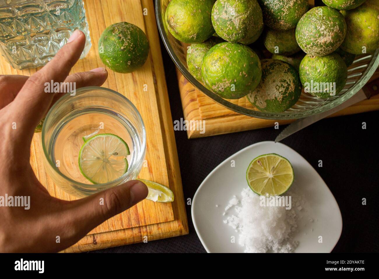 A closeup shot of fresh limes in salt on the table and a man h Stock ...