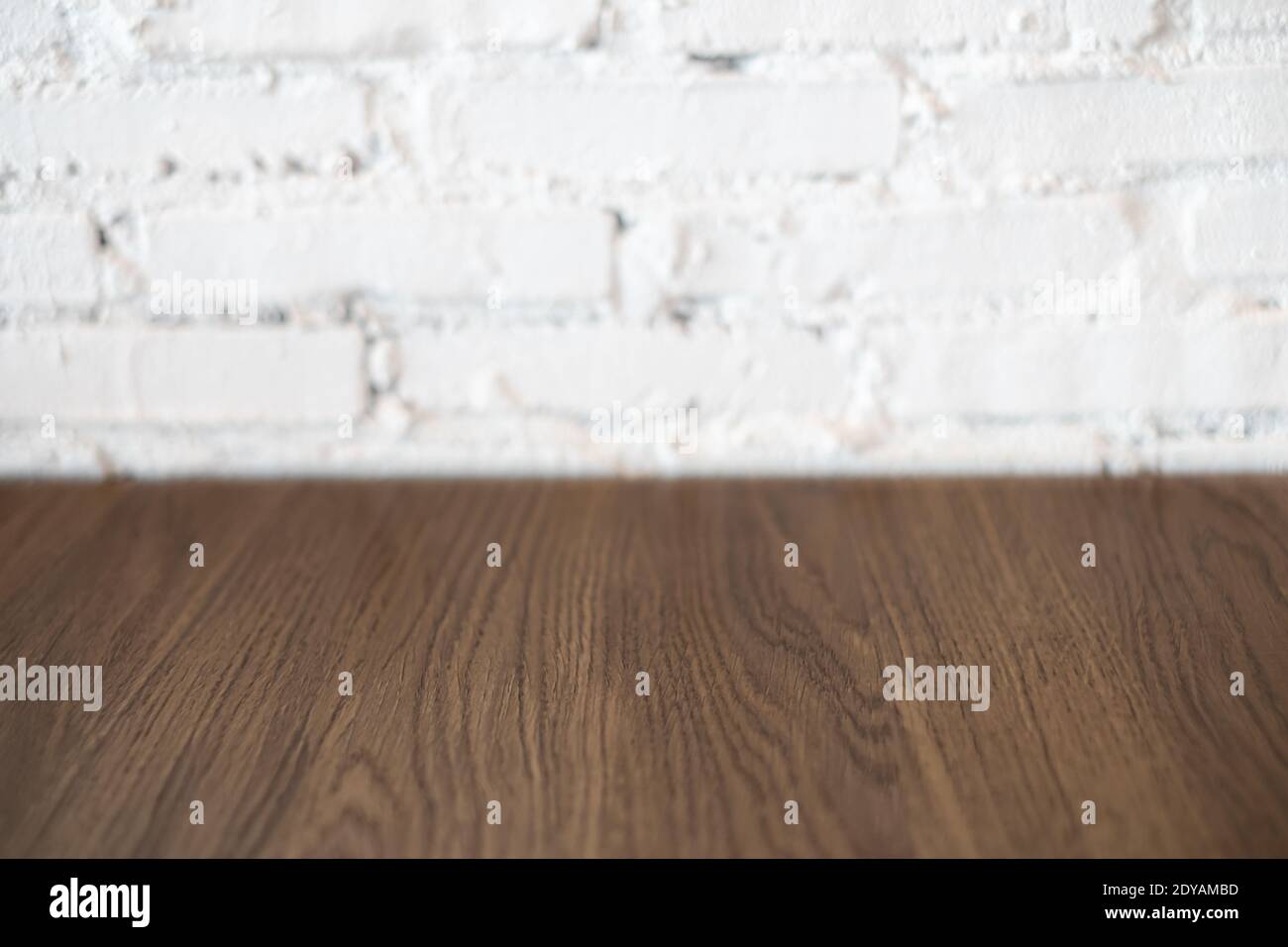 Wood table with white brick wall for background Stock Photo - Alamy